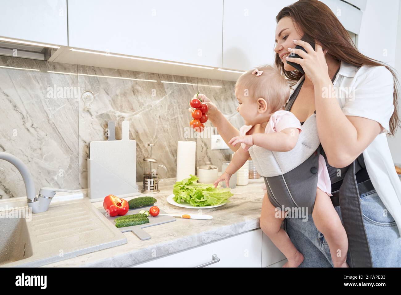 Mom multitasking in kitchen hi-res stock photography and images - Alamy