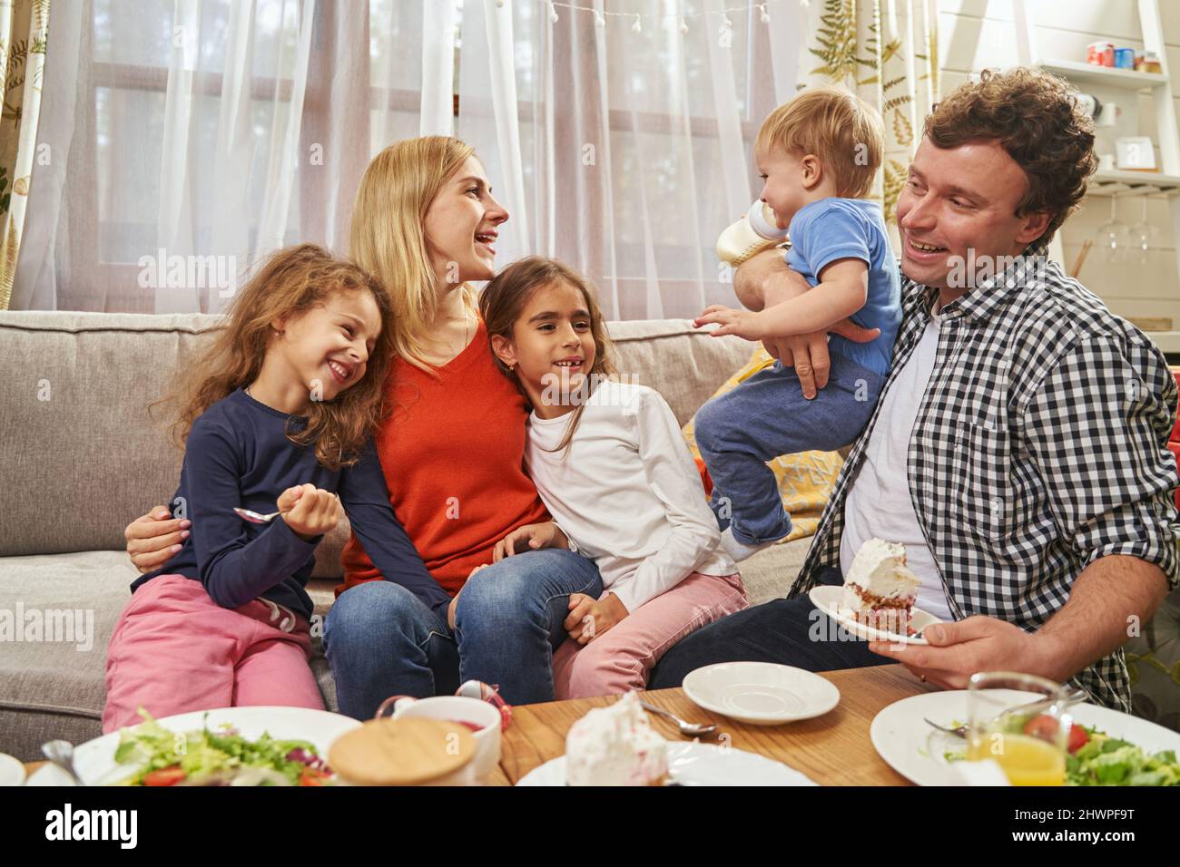 Father holding son, mother hugging daughters and smiling Stock Photo ...