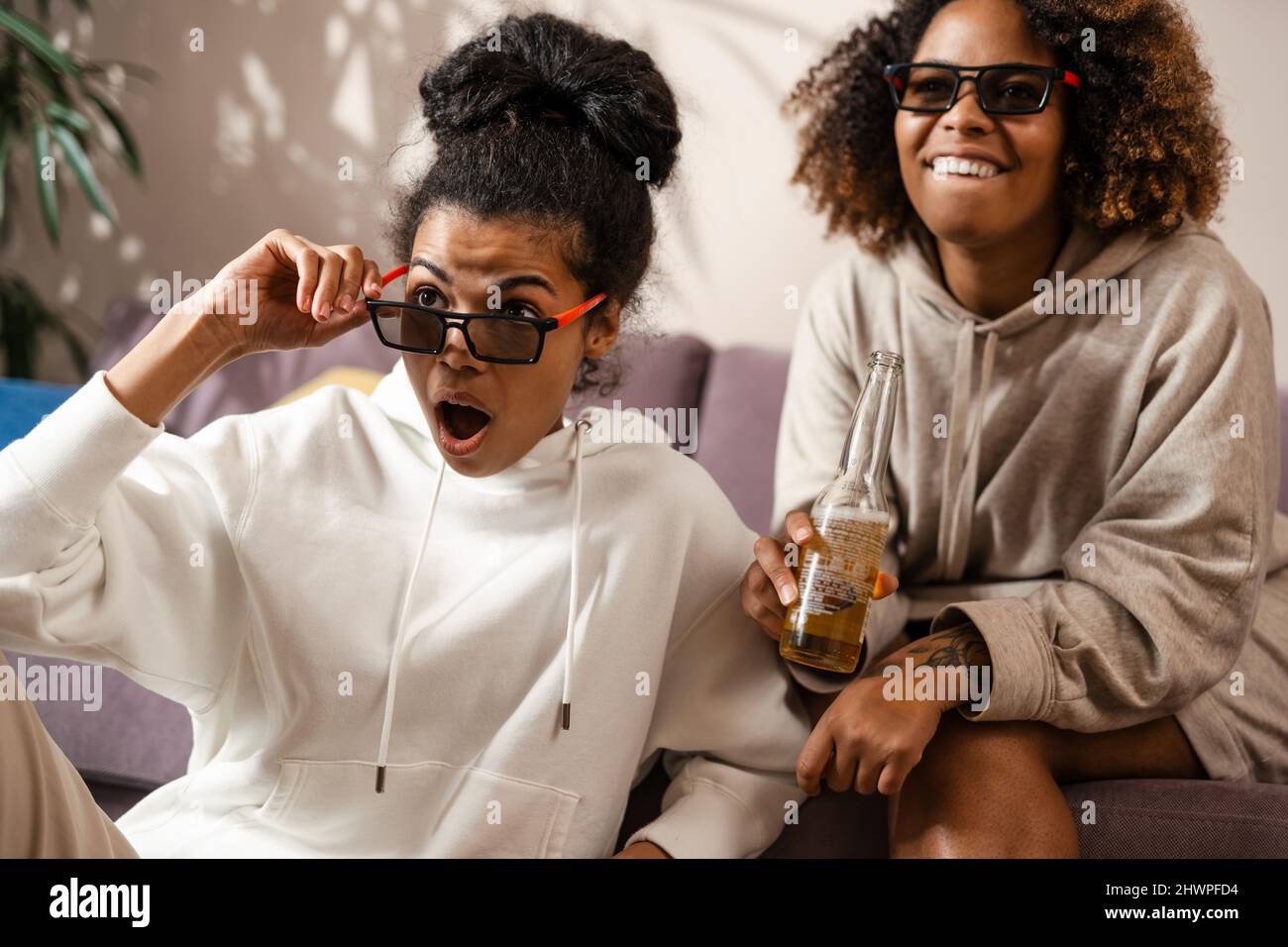 Shocked women sitting on sofa hi-res stock photography and images - Alamy