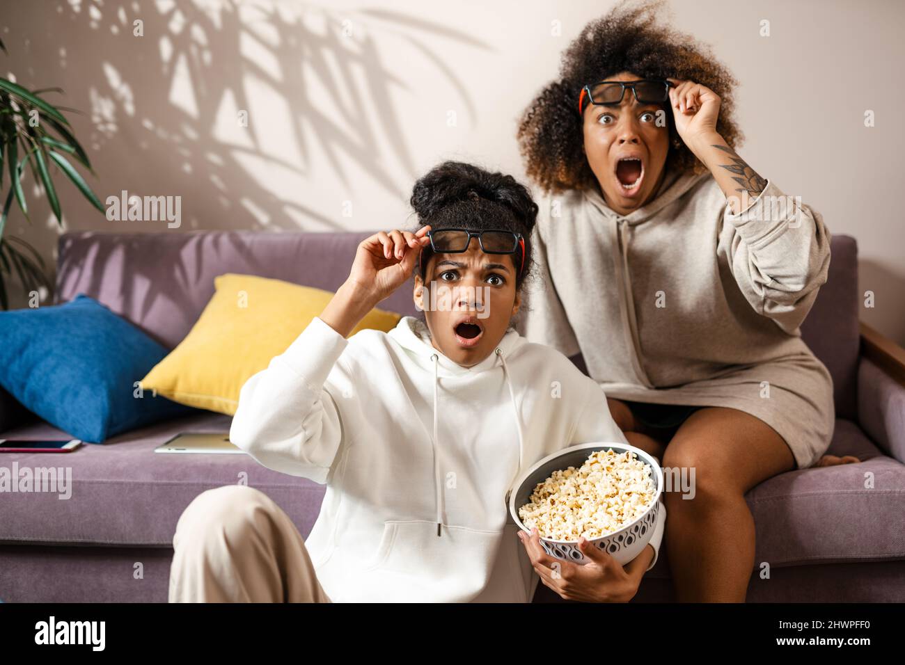 Shocked women sitting on sofa hi-res stock photography and images - Alamy