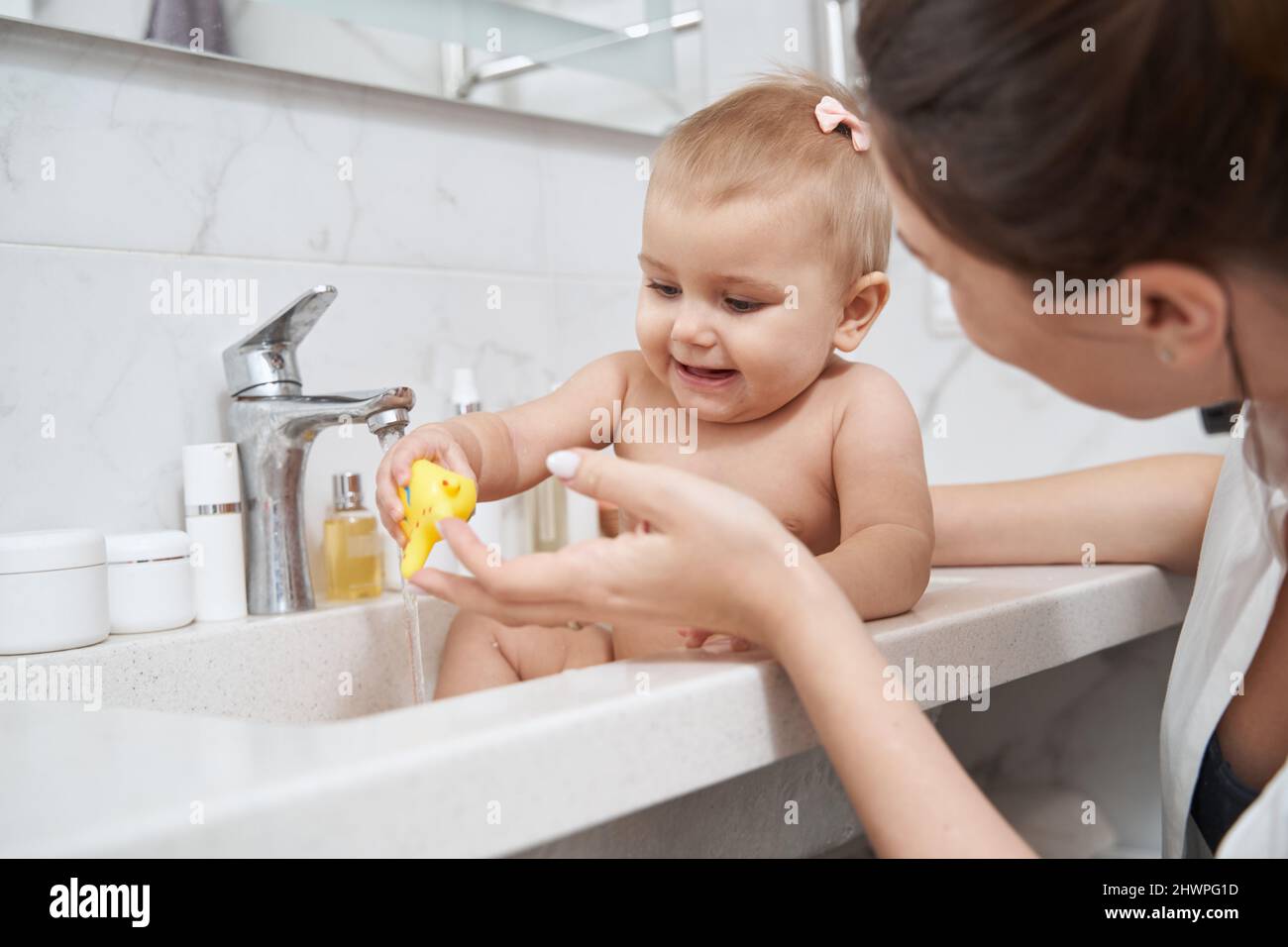 Mother bathing baby in sink hi-res stock photography and images - Alamy