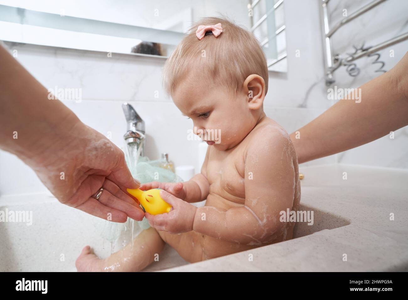 Mother bathing baby in sink hi-res stock photography and images - Alamy