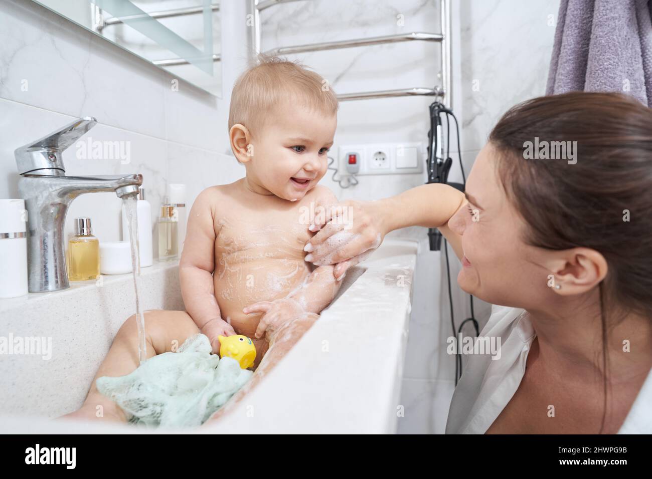 Mother bathing baby in sink hi-res stock photography and images - Alamy
