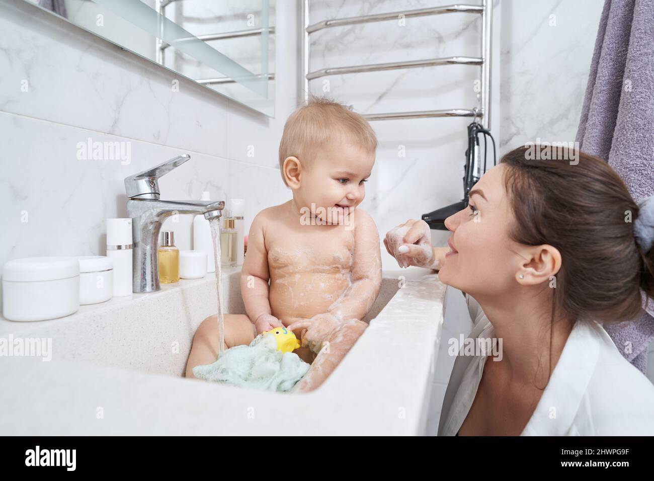 Mother bathing baby in sink hi-res stock photography and images - Alamy