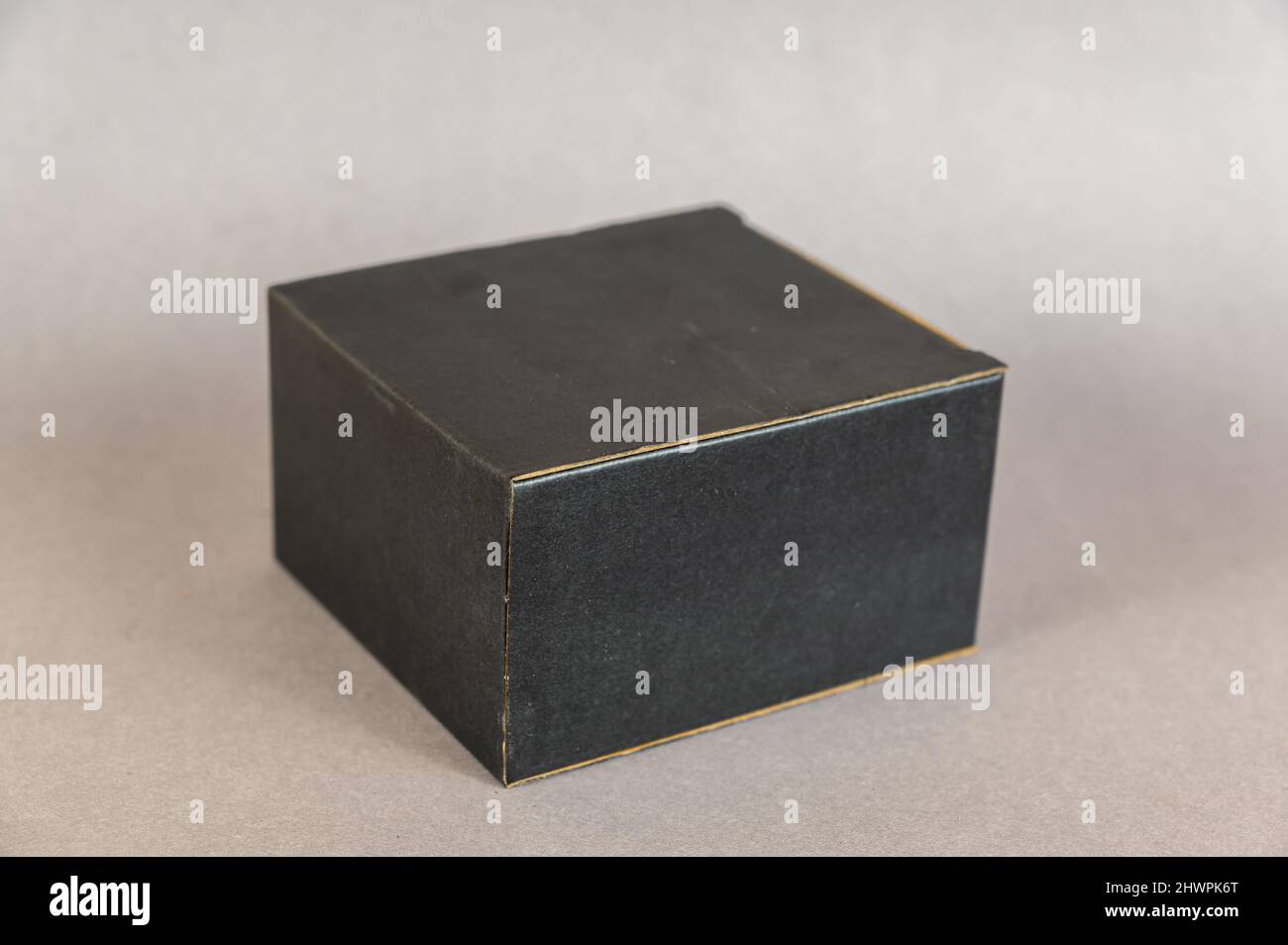 Rectangular black box on a gray background. Closed cardboard package ...