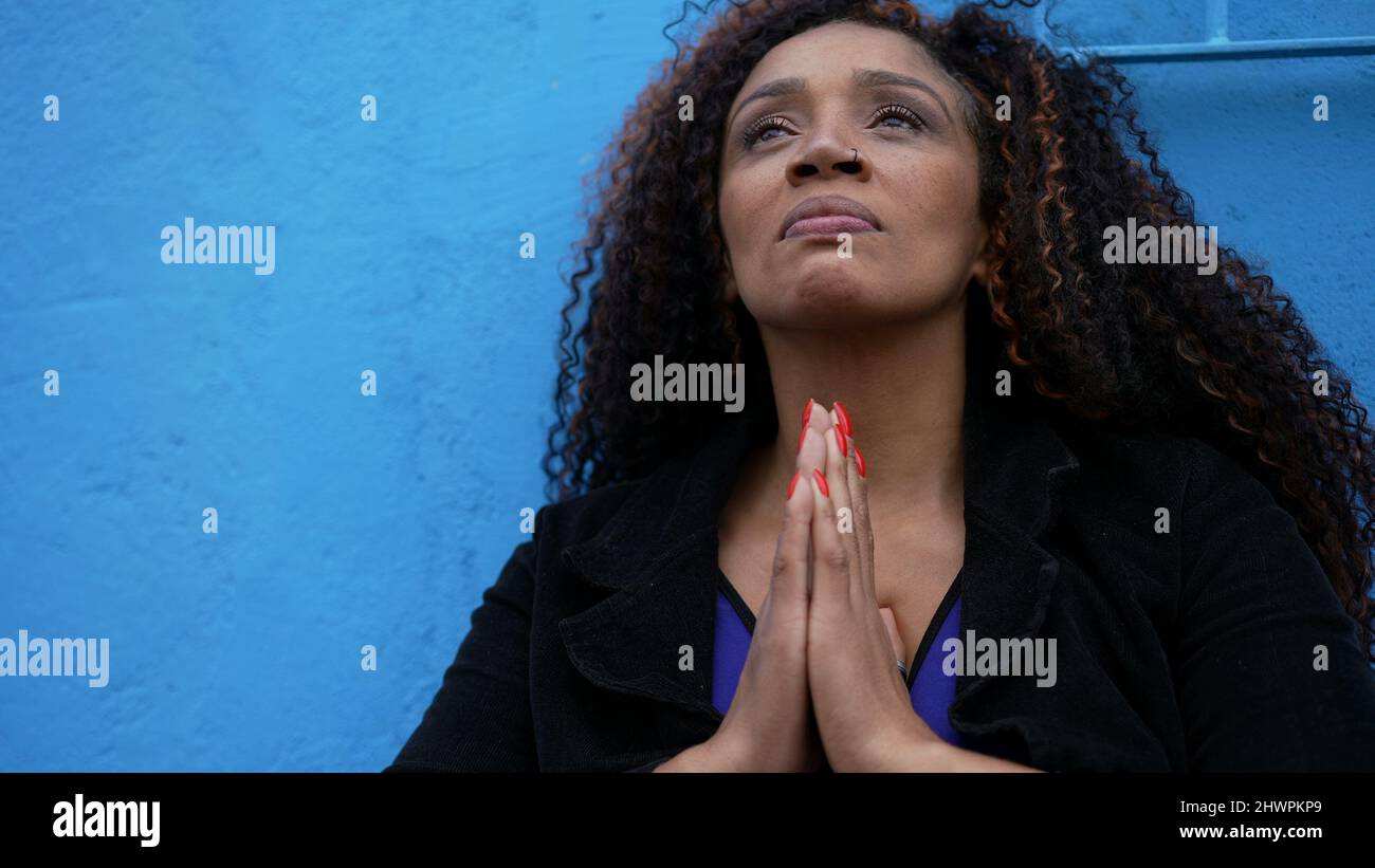 A black woman praying to God having HOPE and FAITH during hard times ...