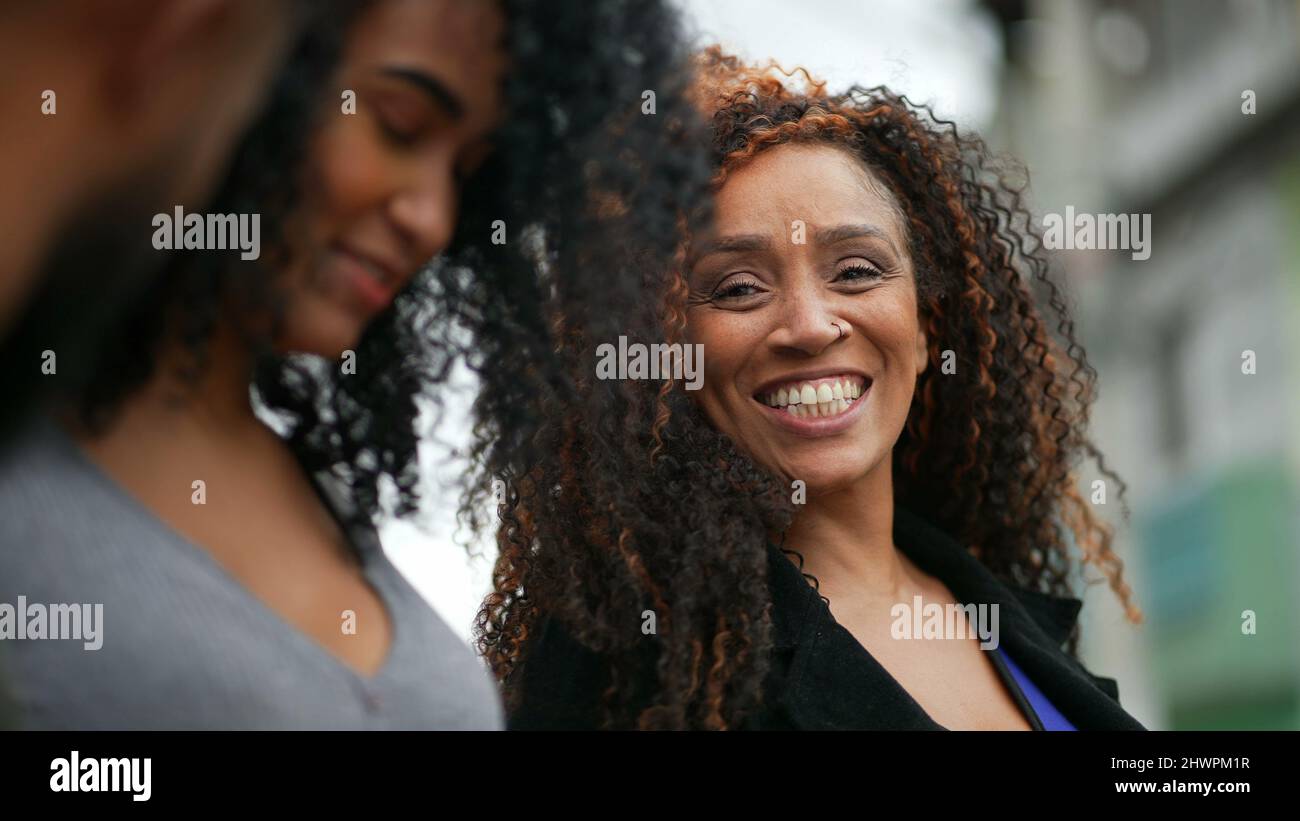 A happy black woman laughing and smiling a casual hispanic 40s lady ...