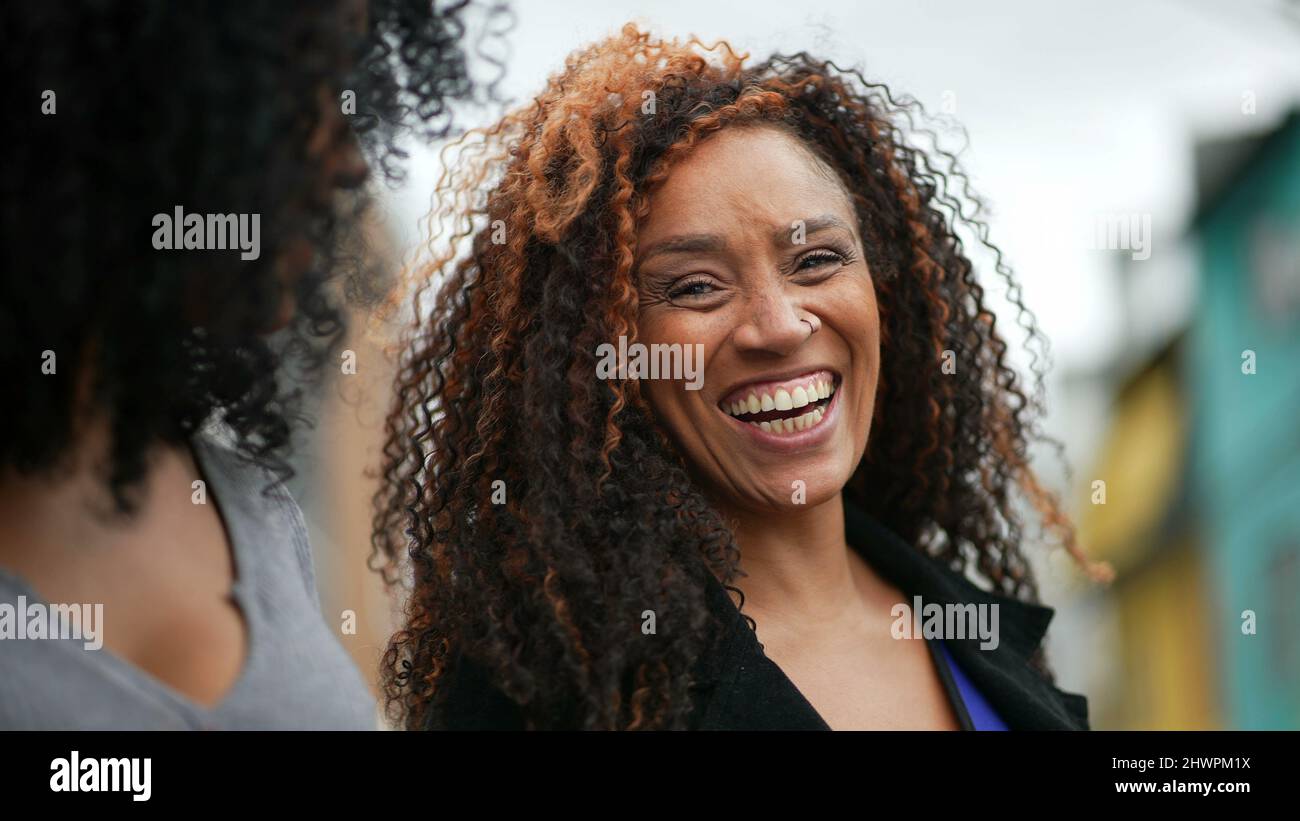 A happy black woman laughing and smiling a casual hispanic 40s lady ...