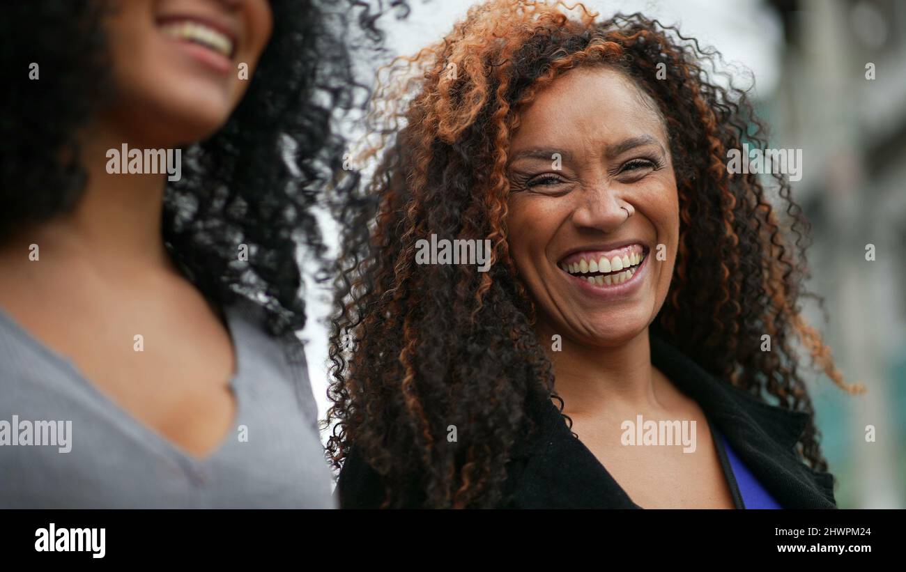 A happy black woman laughing and smiling a casual hispanic 40s lady ...