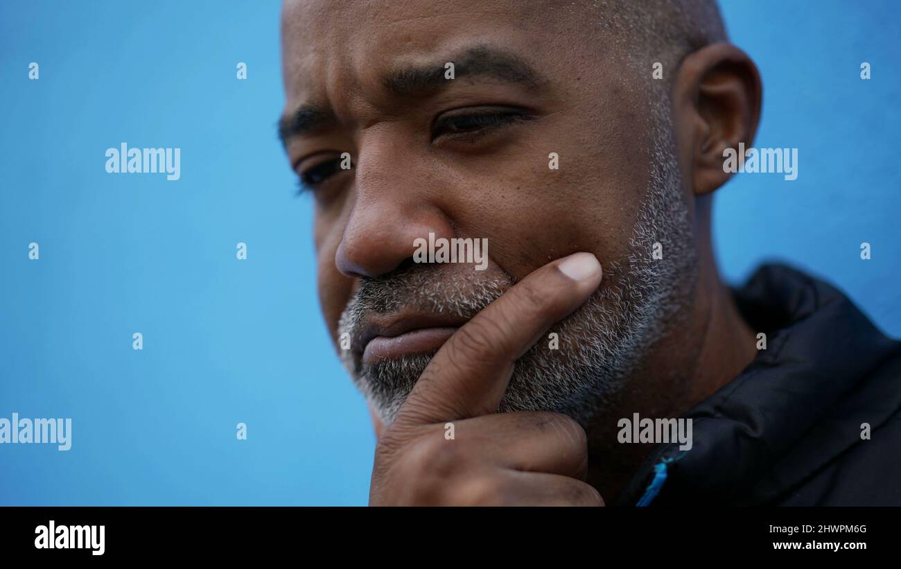 A preoccupied senior man thinking deeply outside in street an african ...
