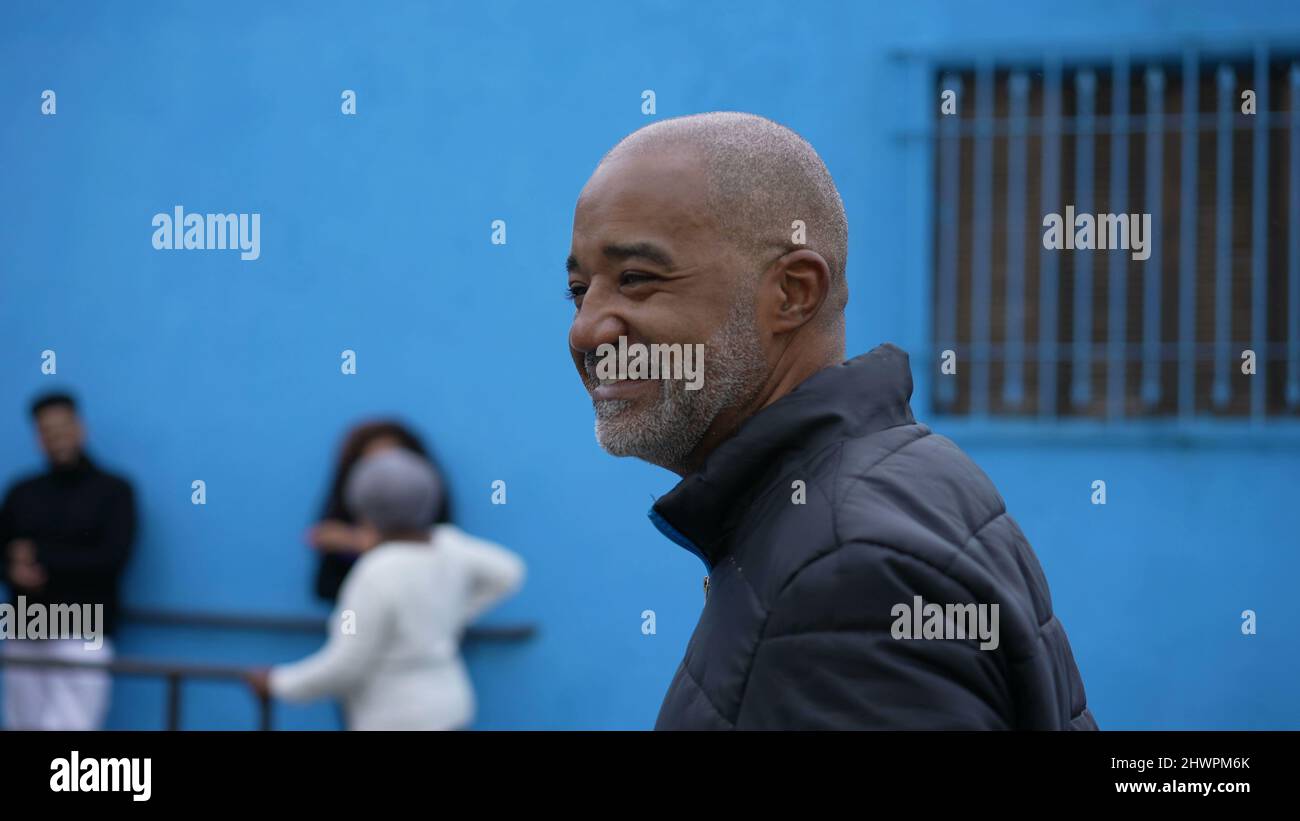 A senior African American person walking outside in street portrait ...