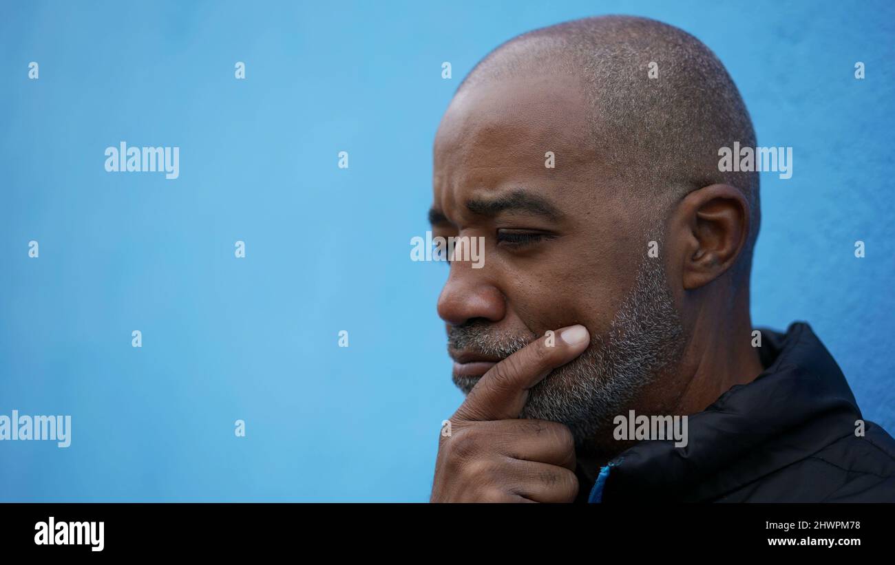A preoccupied senior man thinking deeply outside in street an african ...