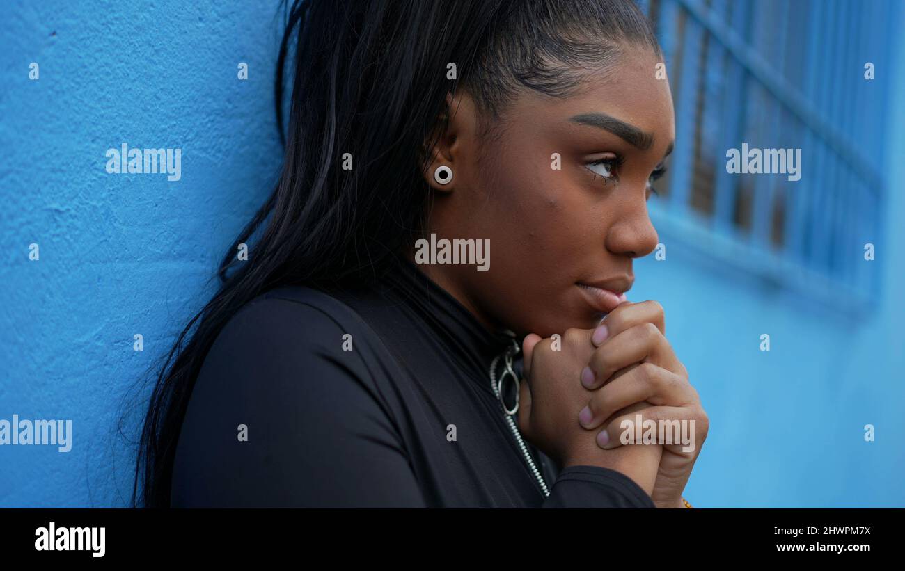 A worried black girl praying to God a pensive preoccupied teenager ...
