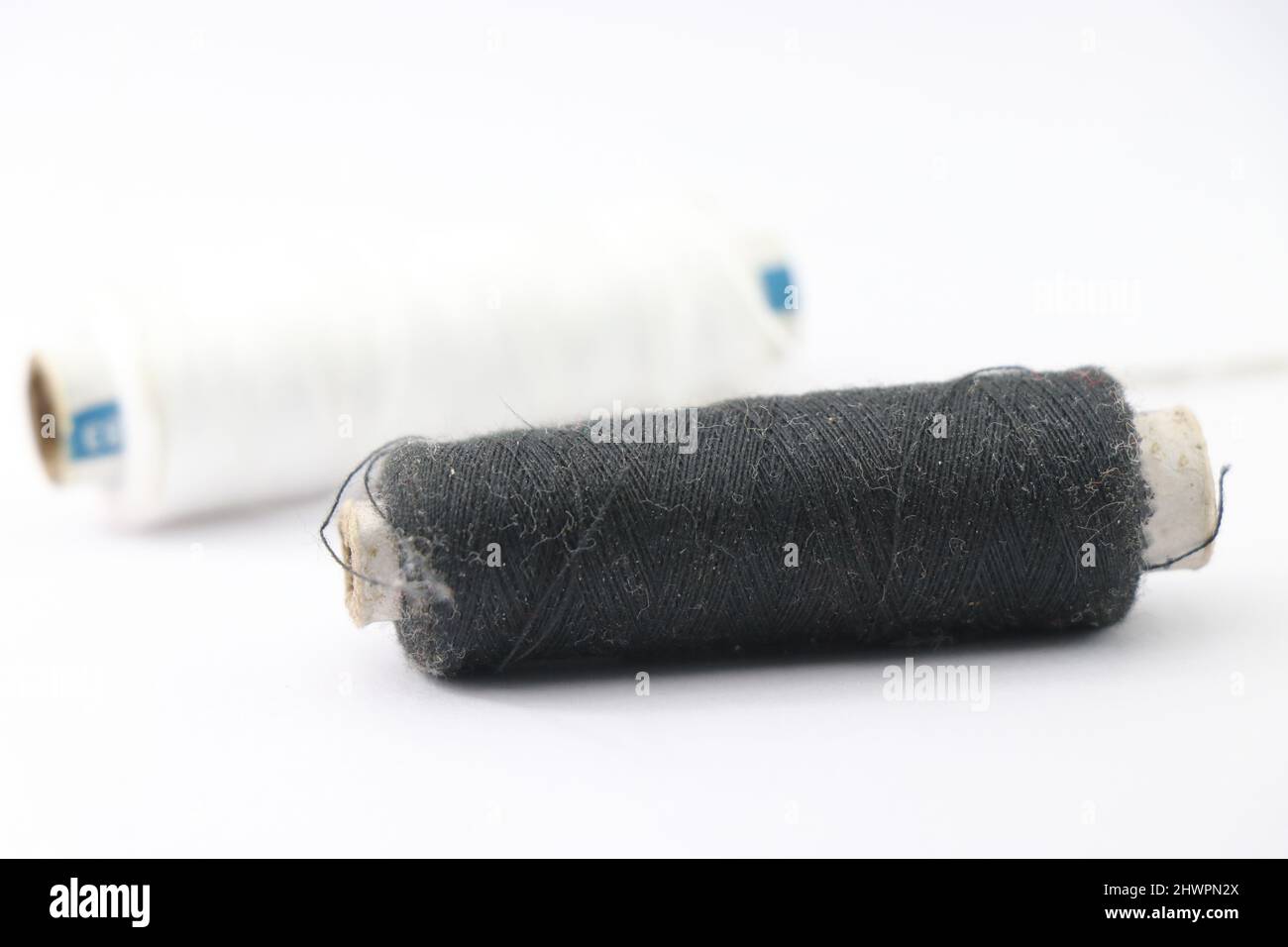 Sewing threads of colors black and white isolated on white background ...
