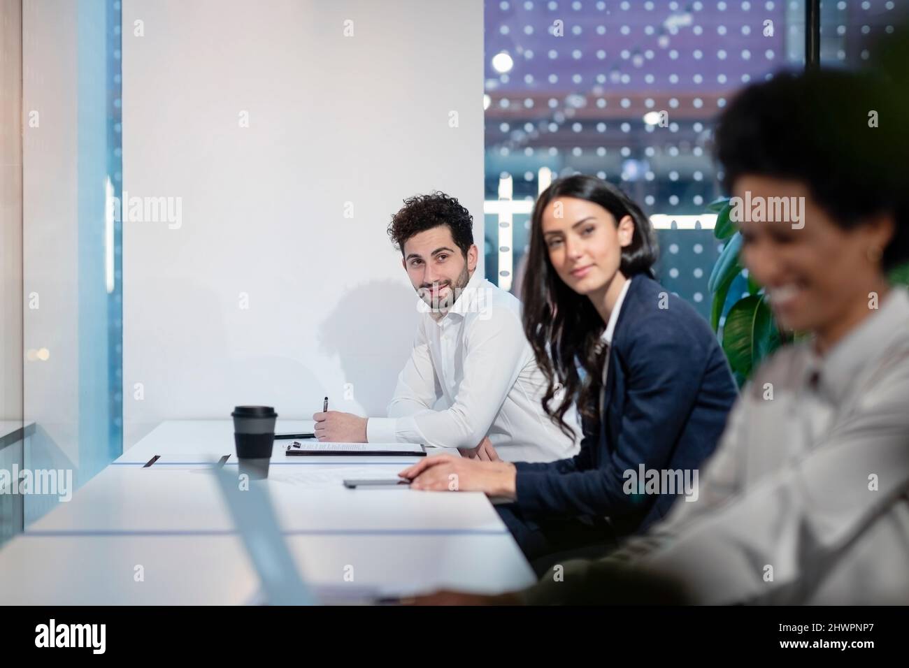 Employees looking at colleague in coworking space Stock Photo - Alamy