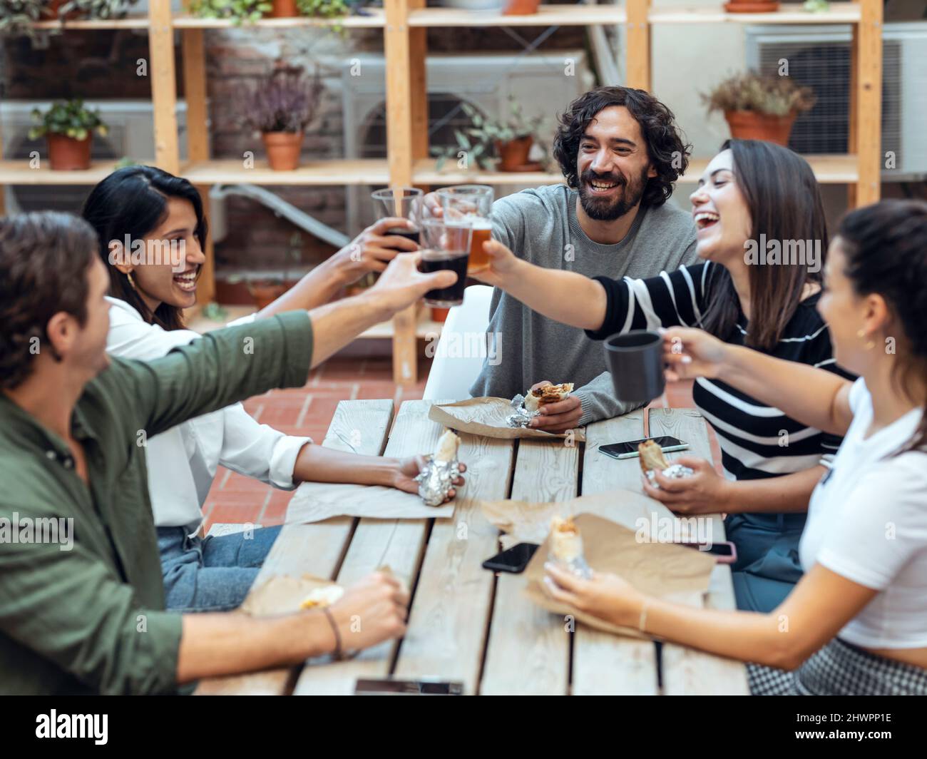 Cheerful businessmen and businesswomen toasting drinks at cafeteria ...
