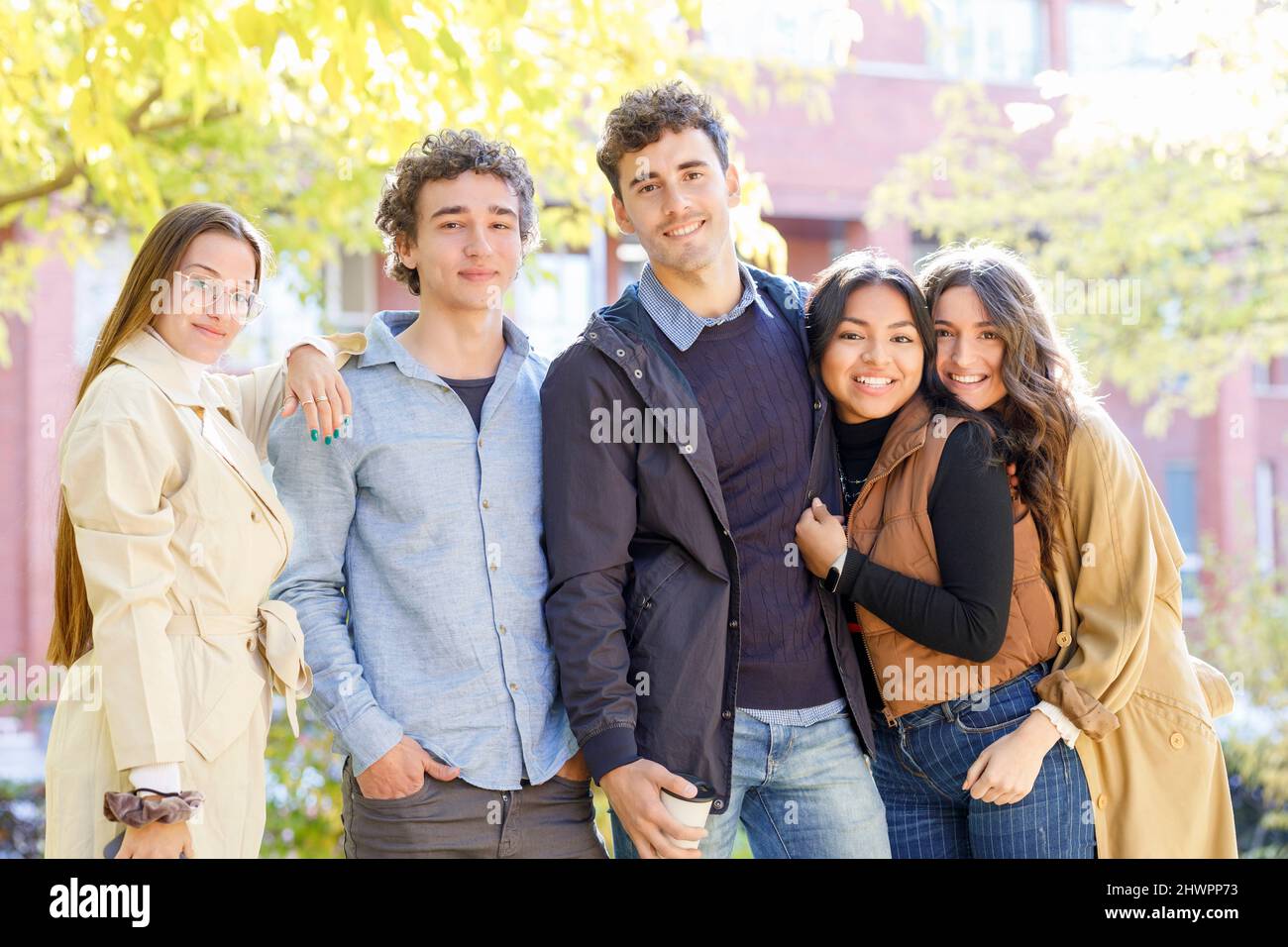 Happy multiracial students standing on university campus Stock Photo ...