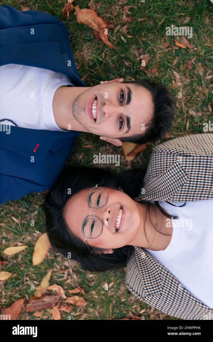 Smiling business colleagues lying together on grass Stock Photo - Alamy