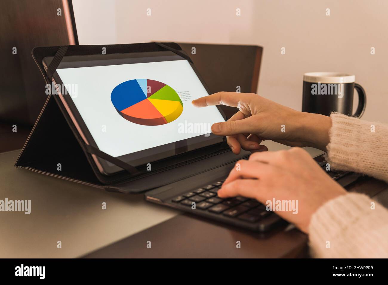 Hand of businesswoman pointing at pie chart on tablet PC screen in ...