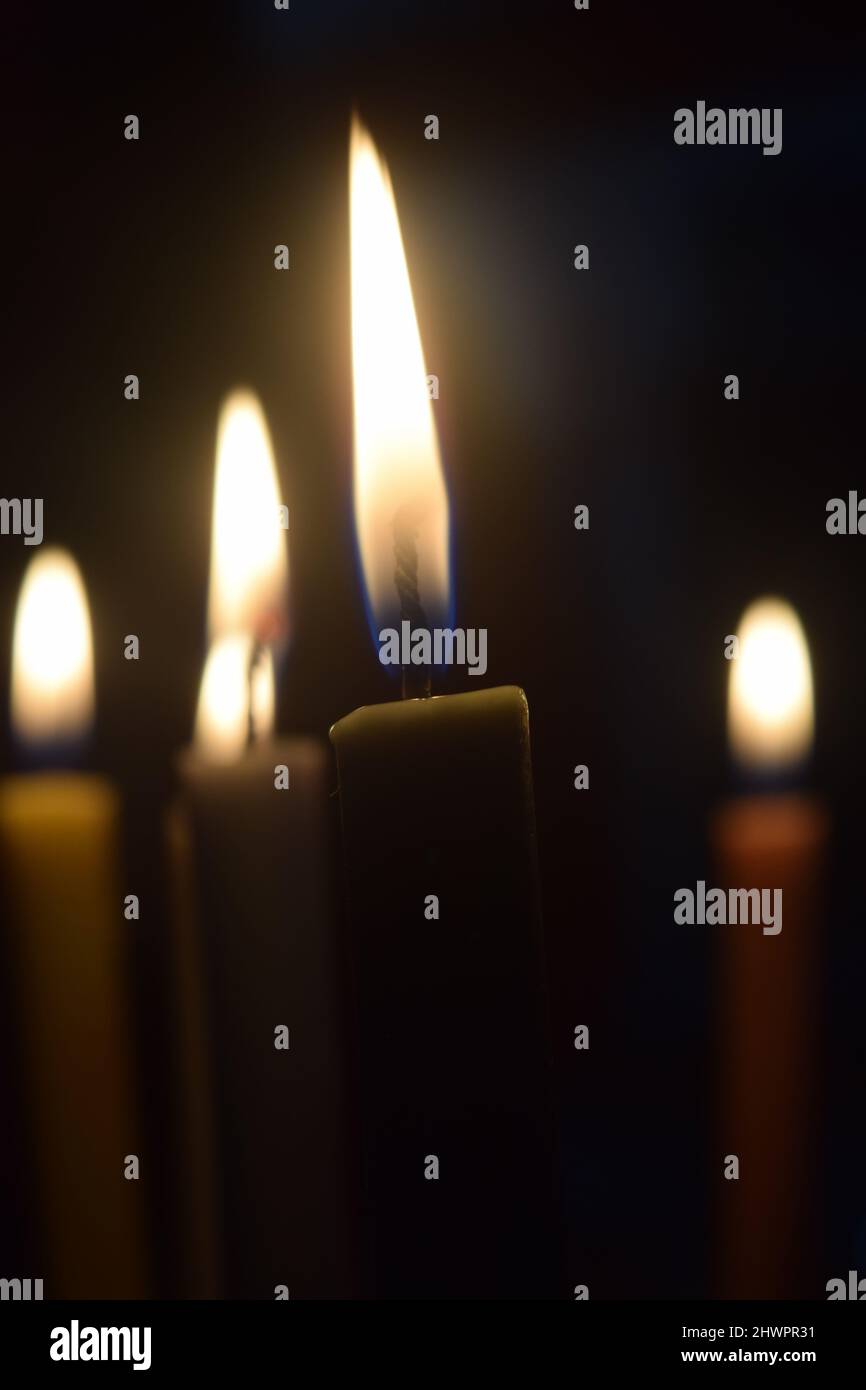 Multiple colourful candles in the dark Stock Photo - Alamy
