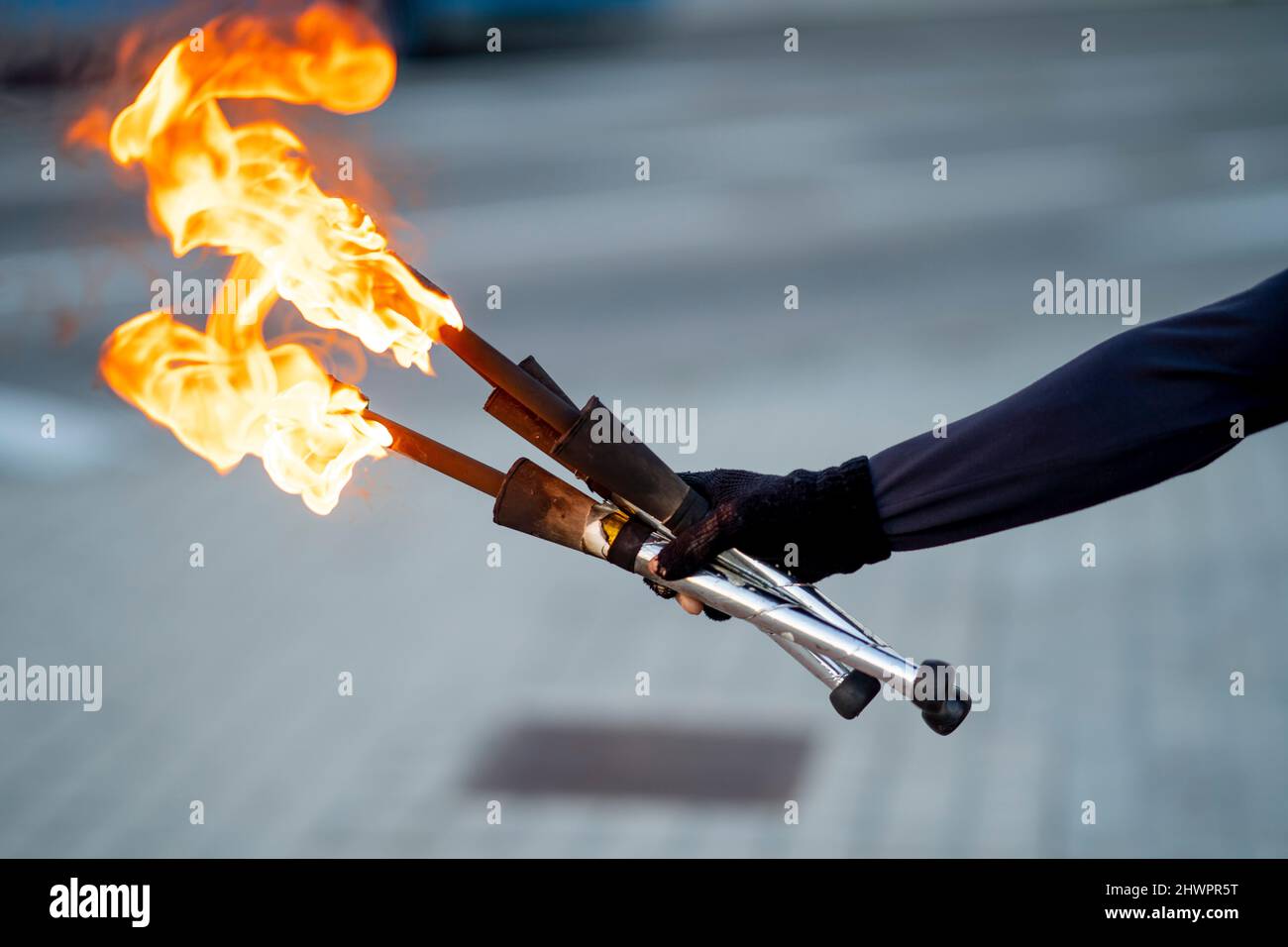 Hand of street artist holding flaming torches Stock Photo - Alamy