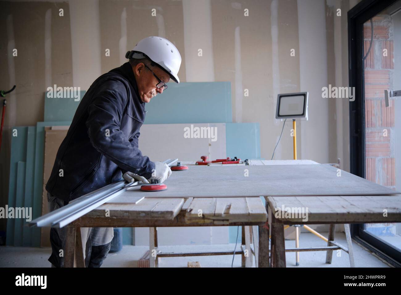 Construction worker with sheetrock on workbench at site Stock Photo - Alamy