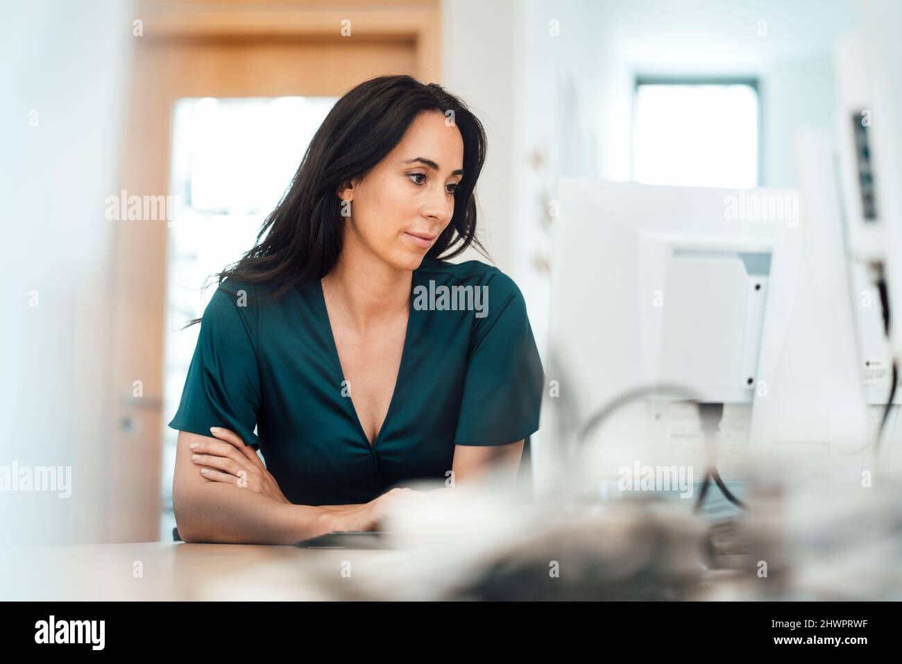 Businesswoman using computer at desk in coworking office Stock Photo ...