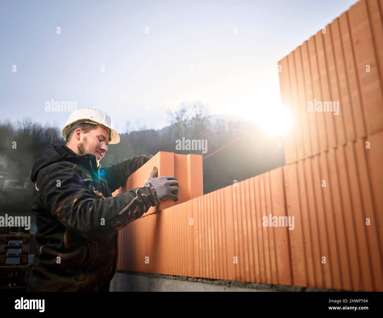 Bricklayer stacking bricks at construction site Stock Photo - Alamy