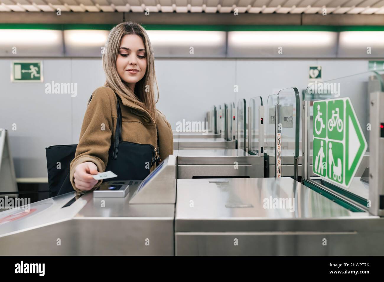 Young woman scanning ticket at subway station Stock Photo - Alamy