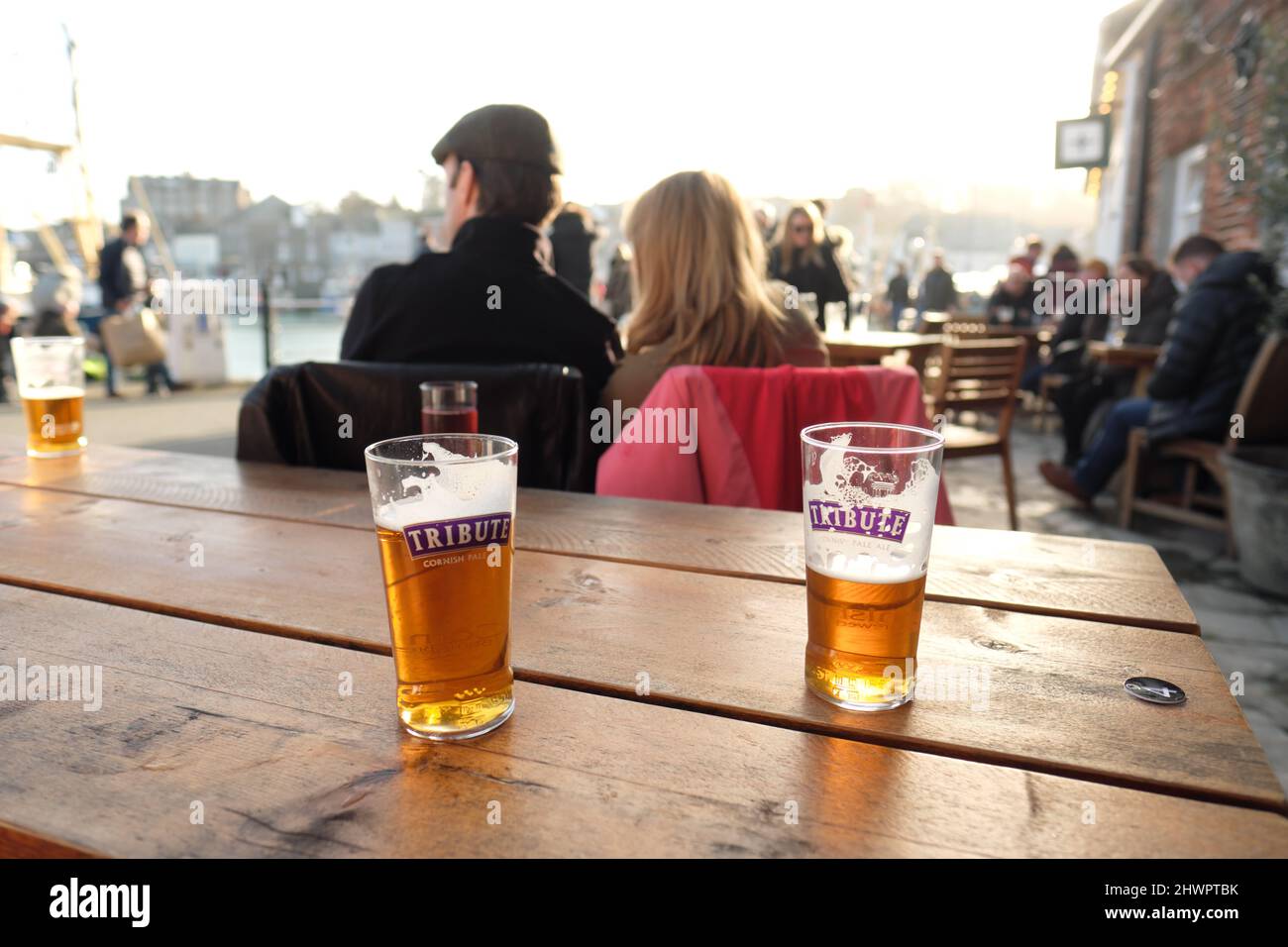 Padstow Cornwall UK - People enjoy a beer outside a pub beside the ...