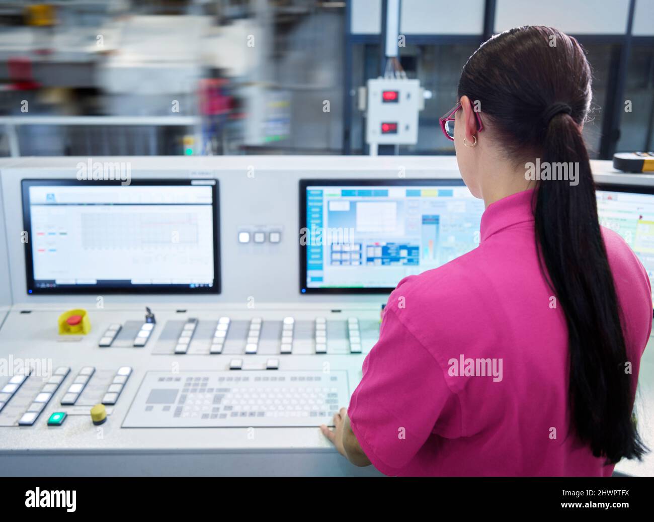 Young industrial employee operating CNC machine in factory Stock Photo ...