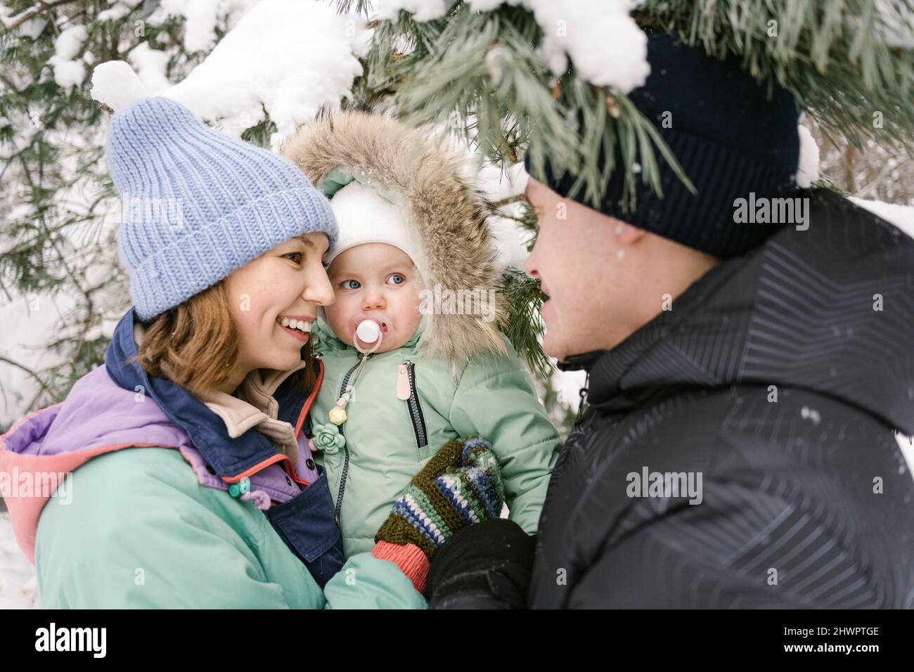 Woman with daughter talking to man under tree in winter Stock Photo - Alamy