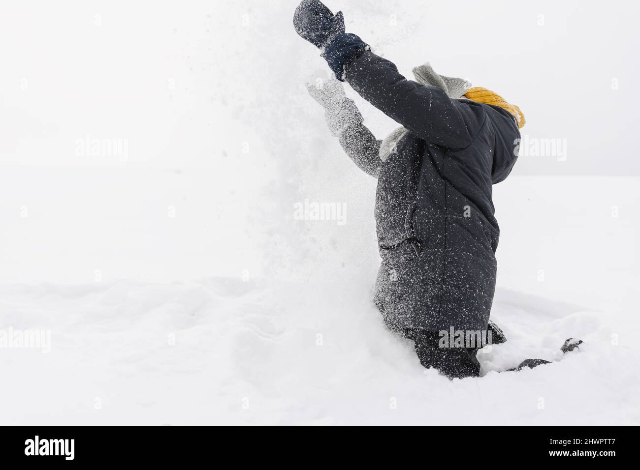Boy enjoying while throwing snow in winter Stock Photo - Alamy