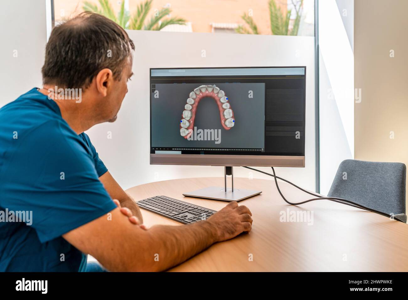 Doctor examining medical X-ray through computer at desk in hospital ...