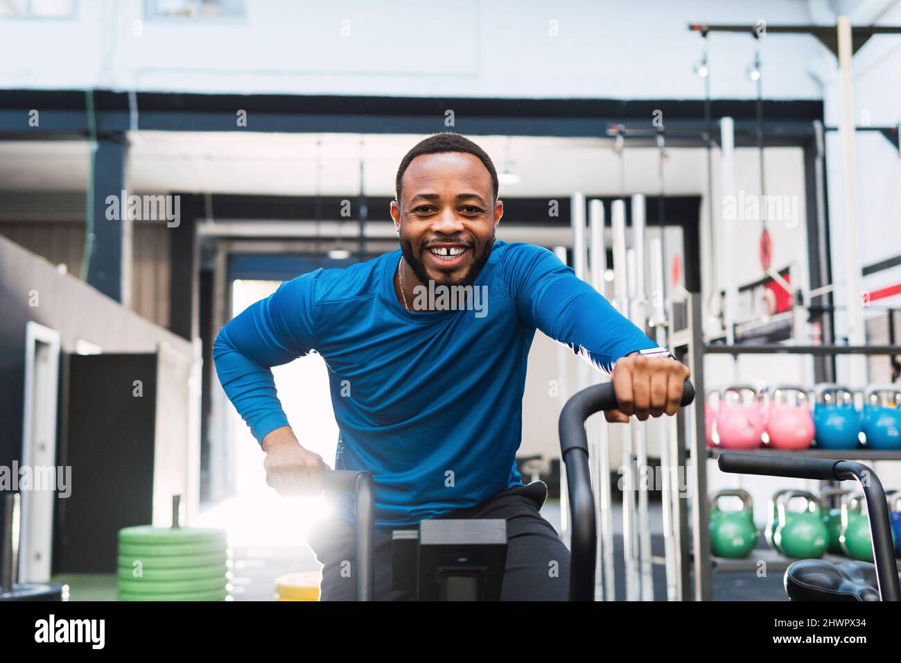 Athlete with gap teeth exercising on airbike in gym Stock Photo - Alamy
