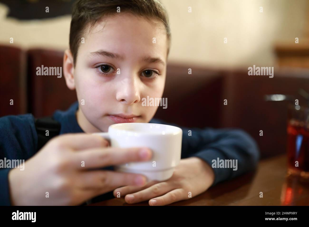 Portrait of boy drinking tea in cafe Stock Photo - Alamy