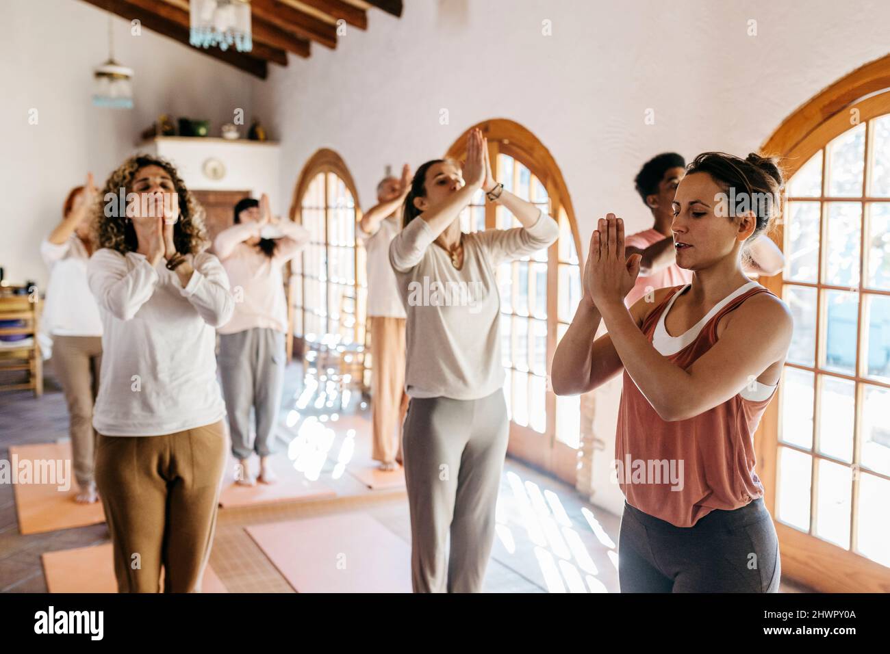 Instructor and students meditating in yoga studio Stock Photo - Alamy