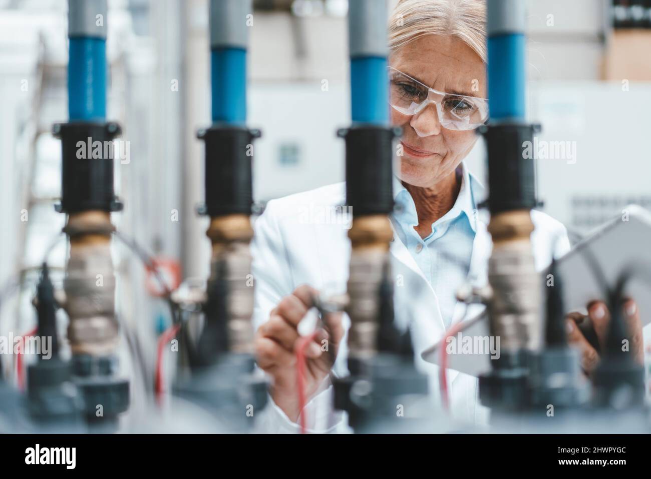 Scientist examining pipes in industry Stock Photo - Alamy