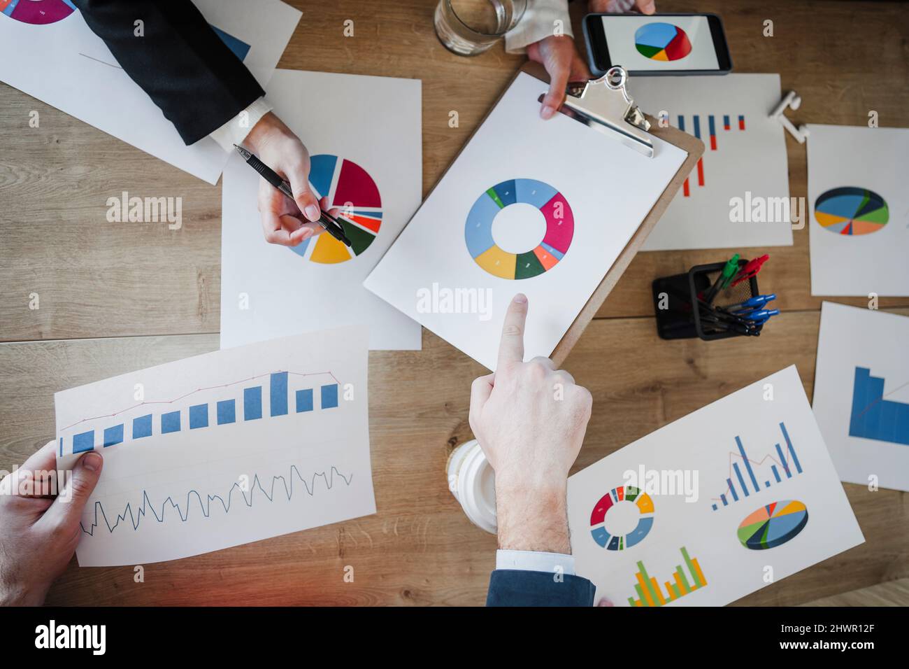Colleagues analyzing business charts in hi-res stock photography and ...