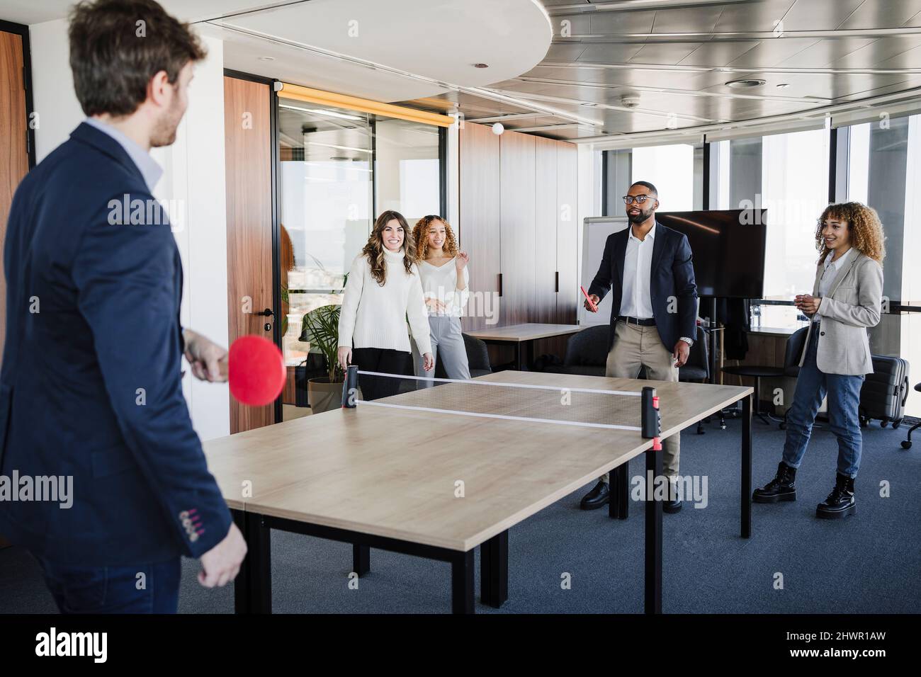 Business colleagues playing table tennis in coworking office Stock ...