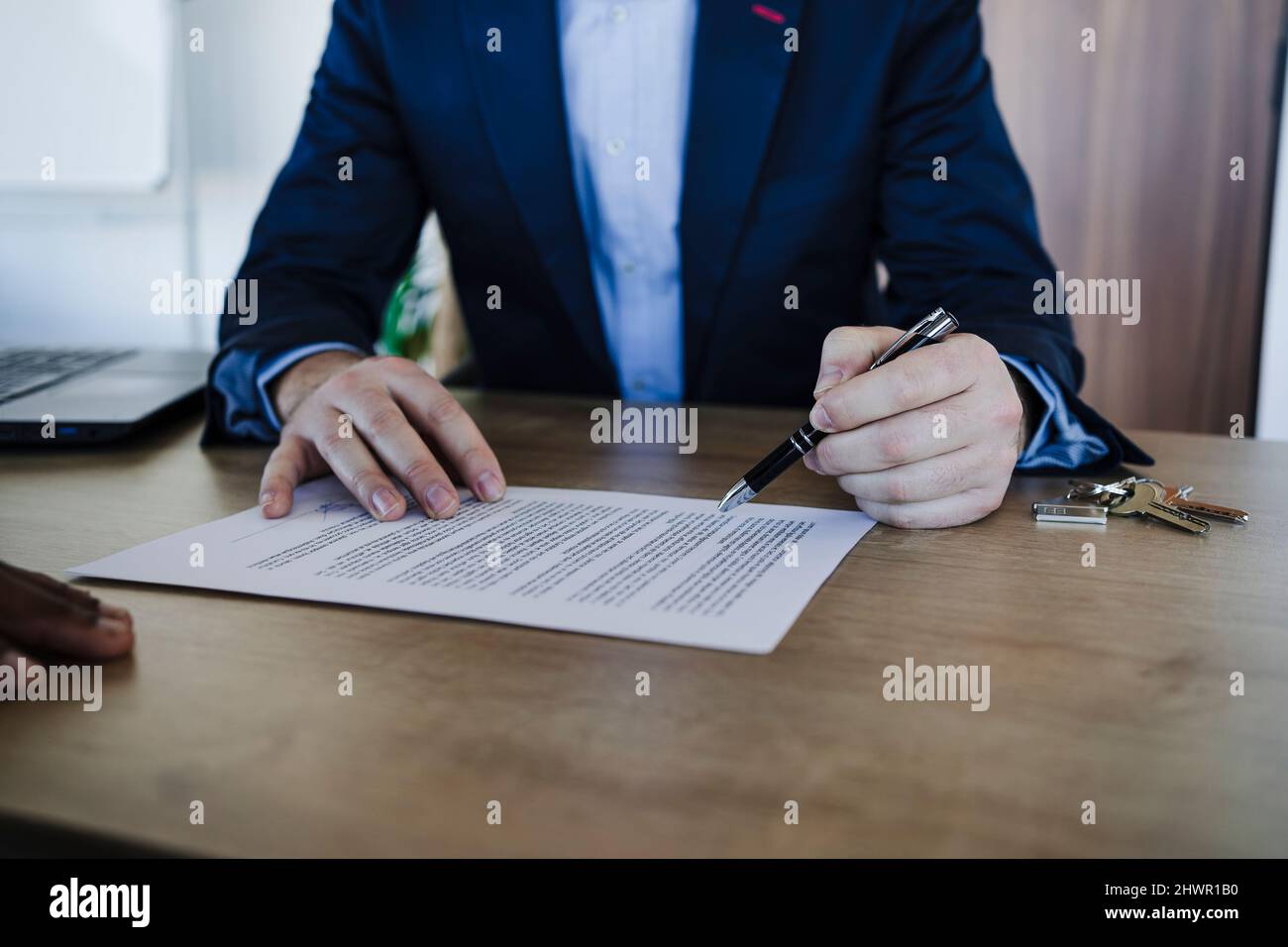 Business colleagues discussing over contract at desk in office Stock ...