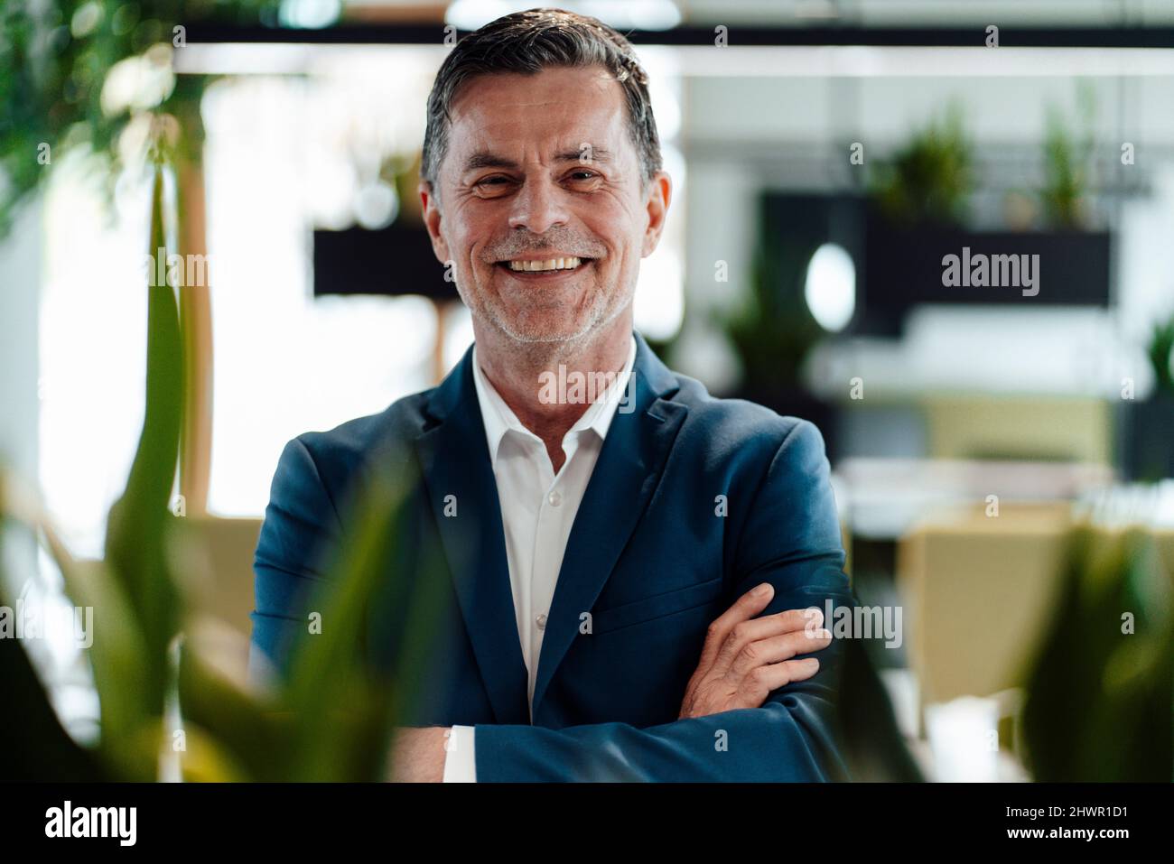 Happy businessman with arms crossed at office Stock Photo - Alamy