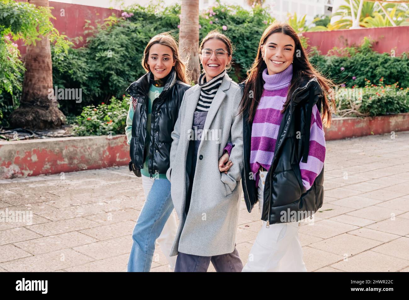 Happy friends walking together on footpath Stock Photo - Alamy