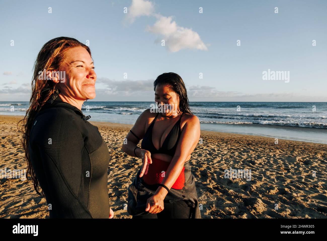 Smiling woman surfer removing wetsuit beach hi-res stock photography ...