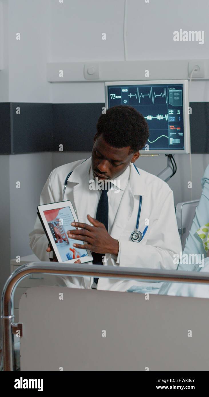 Man explaining cardiology diagnosis to patient with illness in bed ...