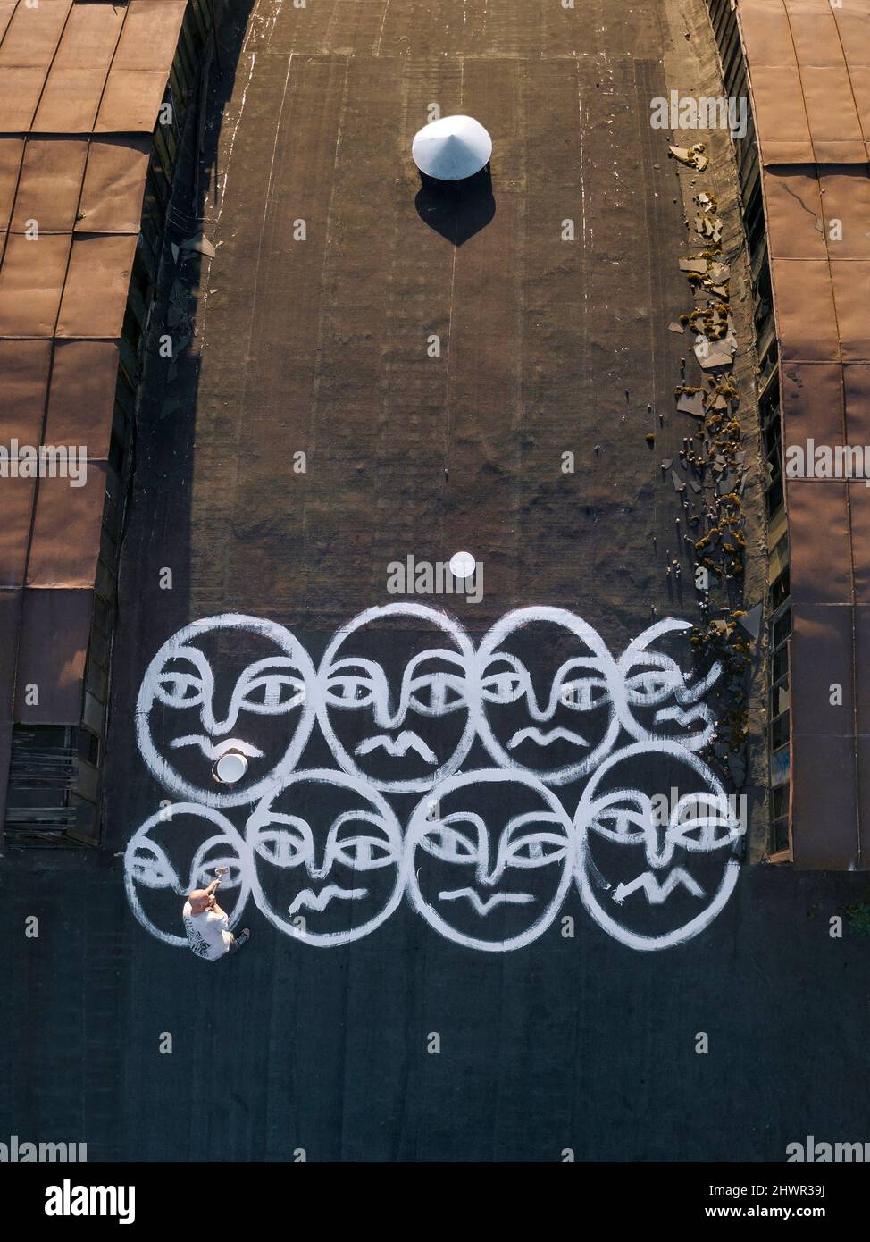 Painter standing by graffiti on rooftop Stock Photo - Alamy