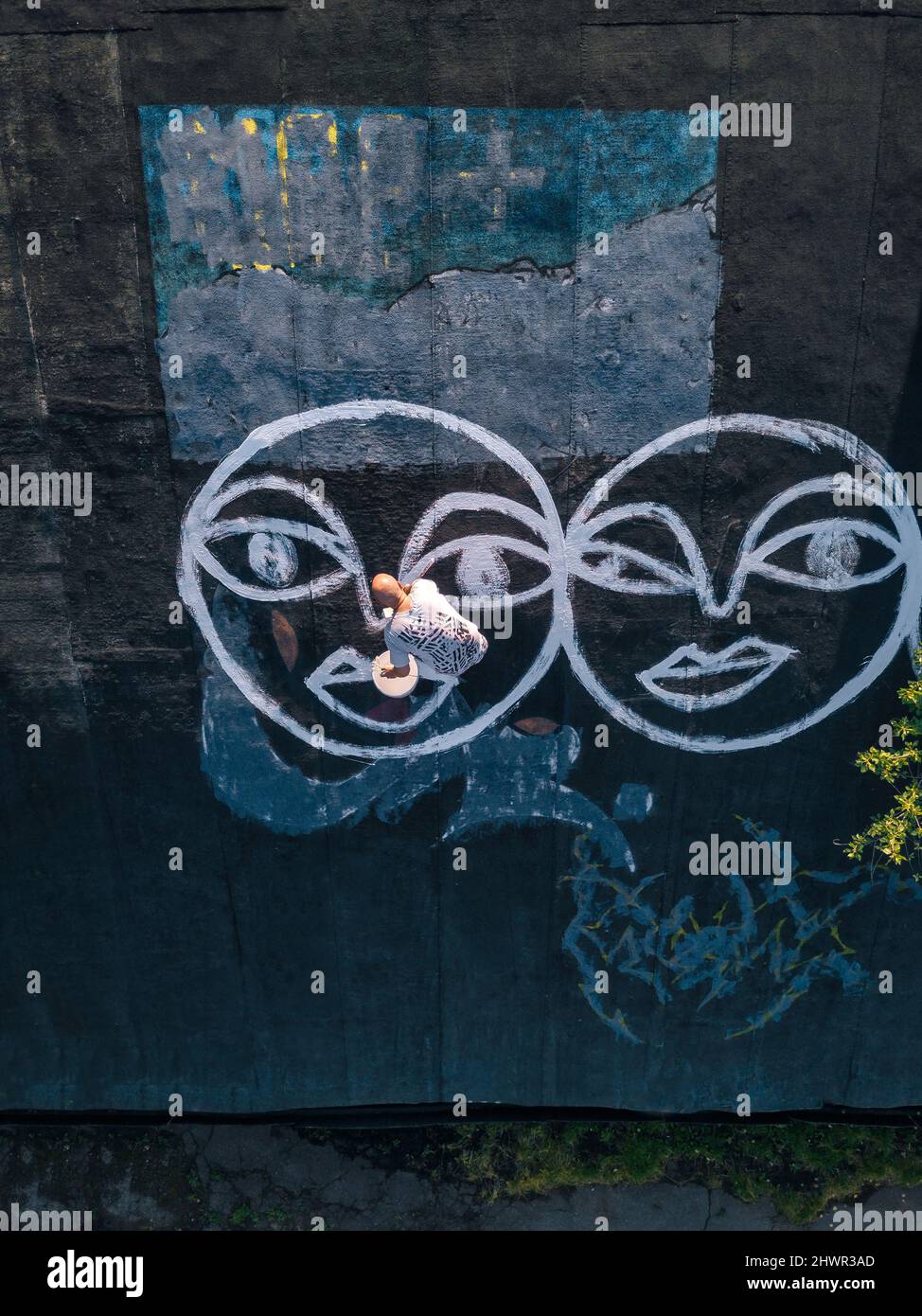 Painter painting smiley graffiti on roof Stock Photo - Alamy