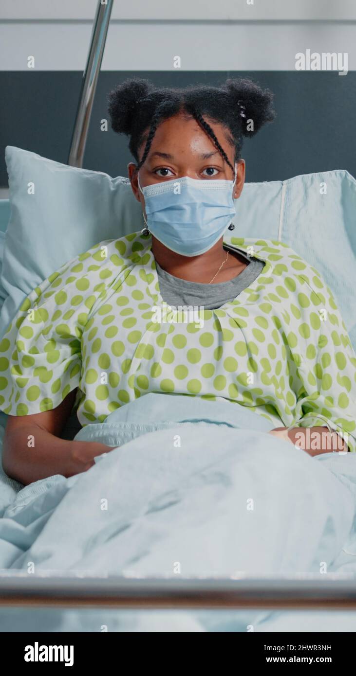 Portrait of african american patient wearing face mask and waiting to ...