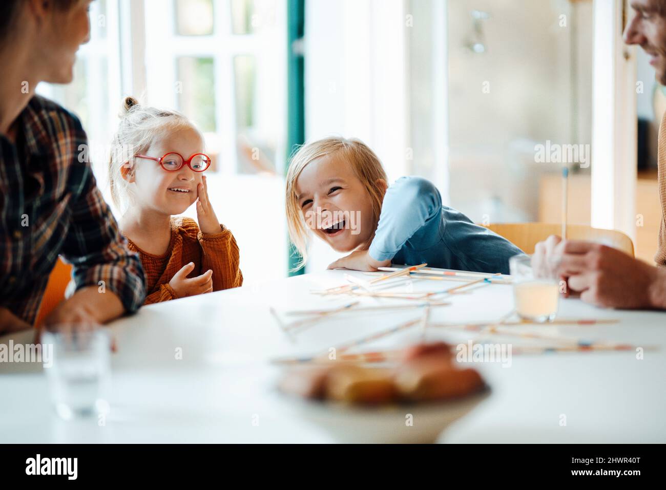 Brother and sister laughing by parents at home Stock Photo - Alamy