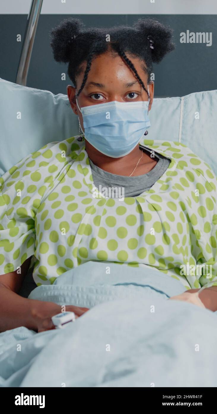 Portrait of patient with sickness wearing face mask and waiting on ...